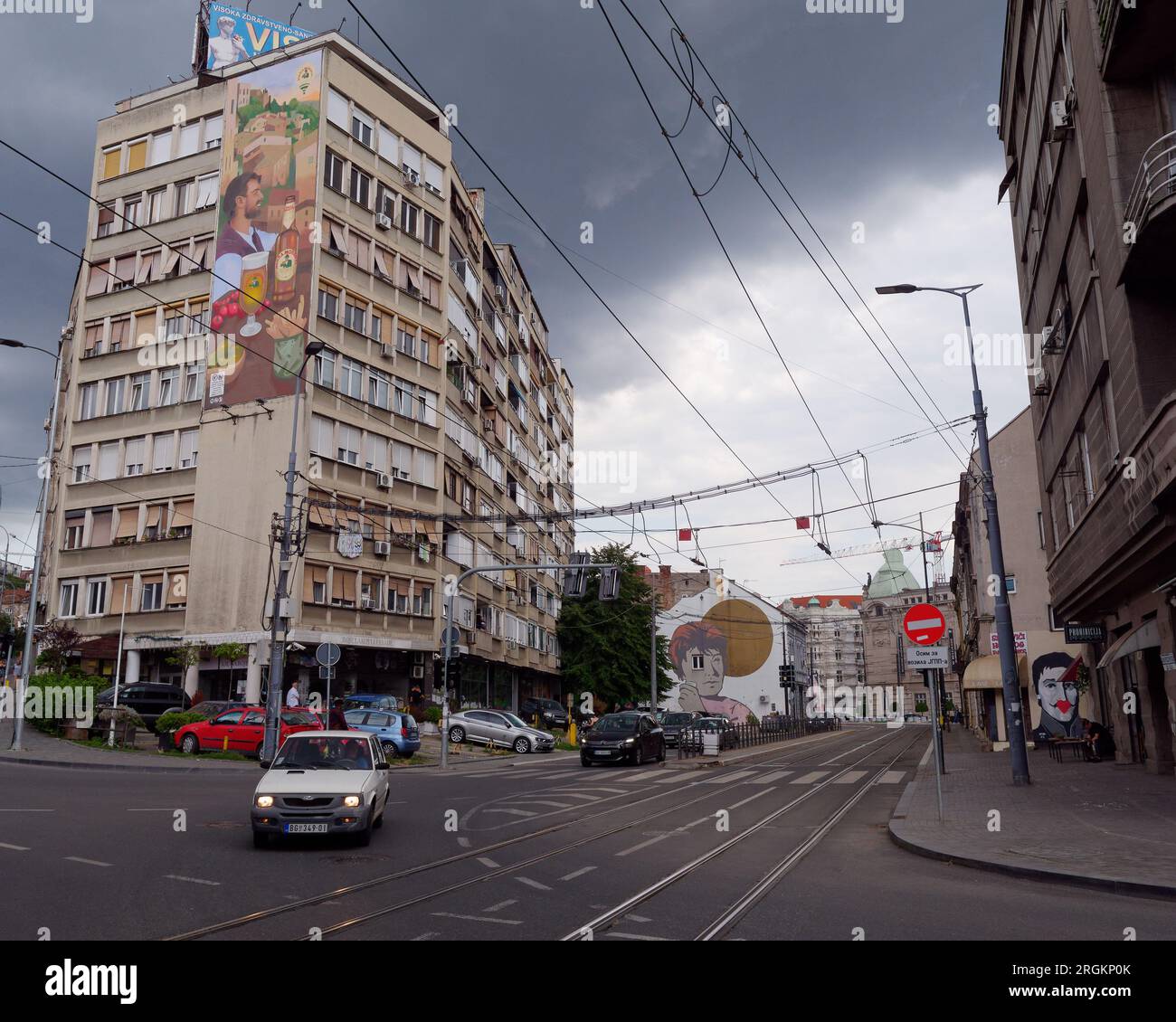 High Rise apartment block with street art with cars at a road junction ...
