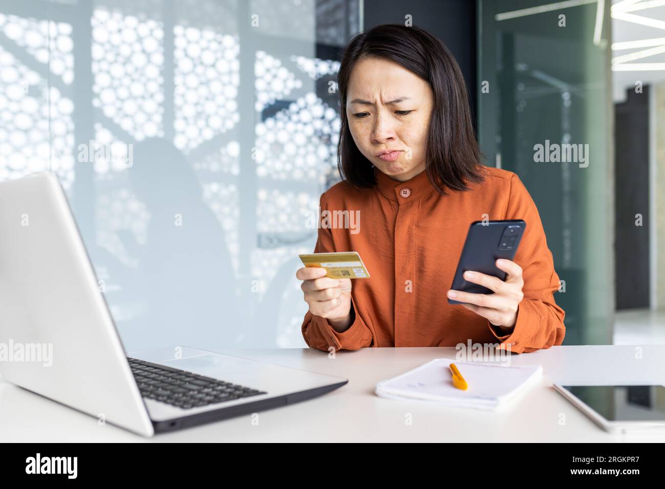 Upset and disappointed woman inside office at workplace, cheated asian ...