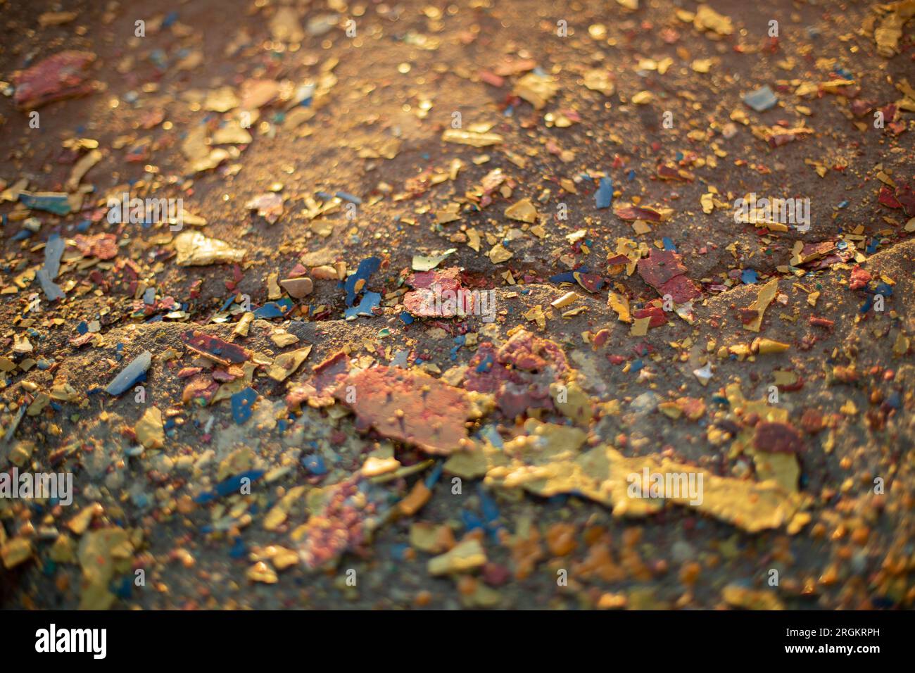 Pieces of paint lie on asphalt. Texture of colored dirt. Small dust ...