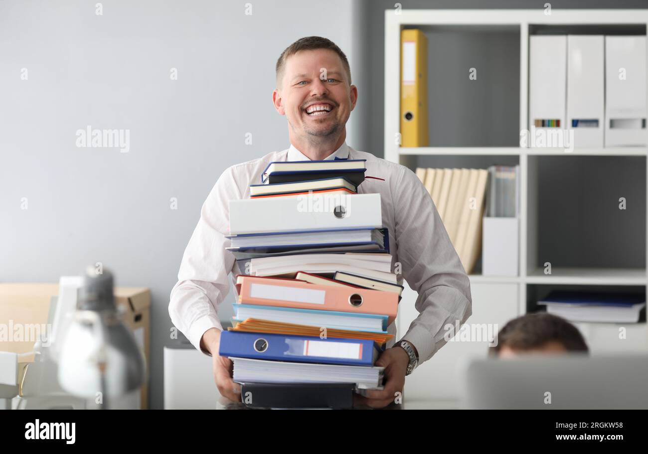 Happy office worker carry huge heavy pile of paper Stock Photo - Alamy