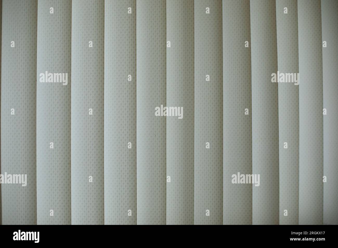 Blinds are white. Vertical blinds on window. Light from window ...