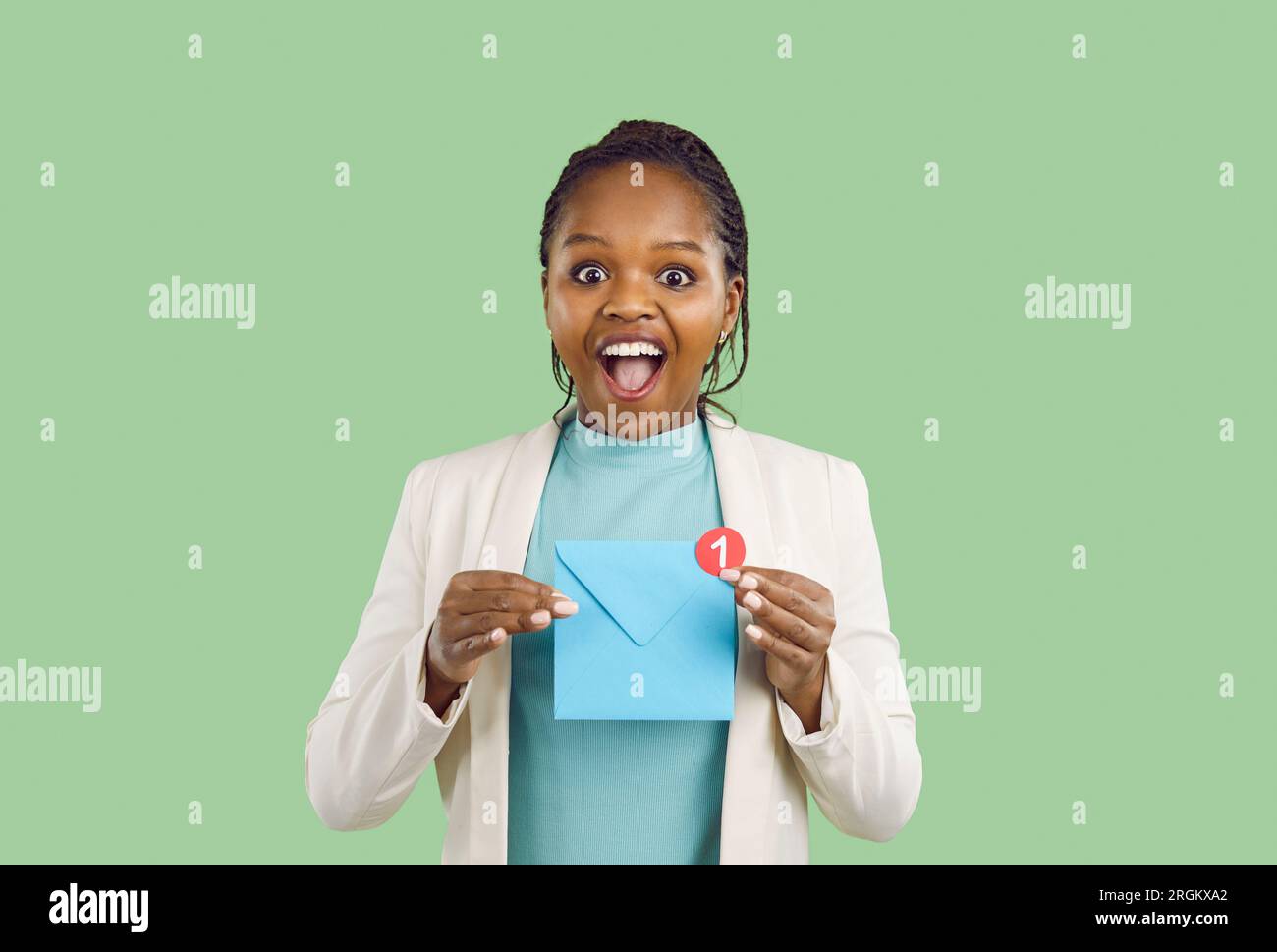 Happy excited woman on light green background holding envelope ...