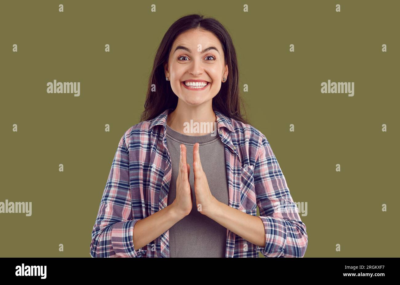 Smiling surprised excited young brunette woman in plaid shirt clapping ...