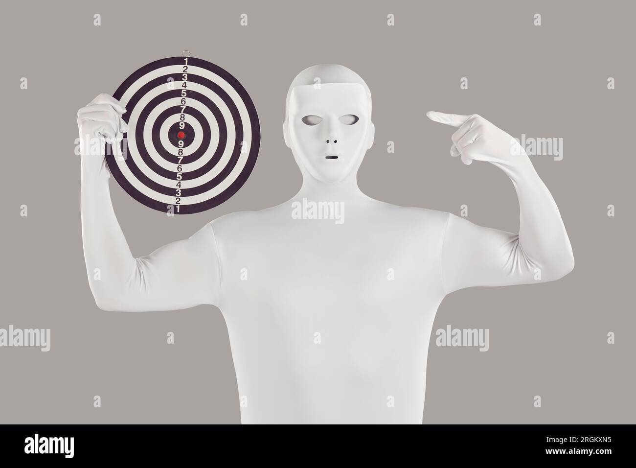 Man disguised in a white bodysuit and mask pointing at a target board ...