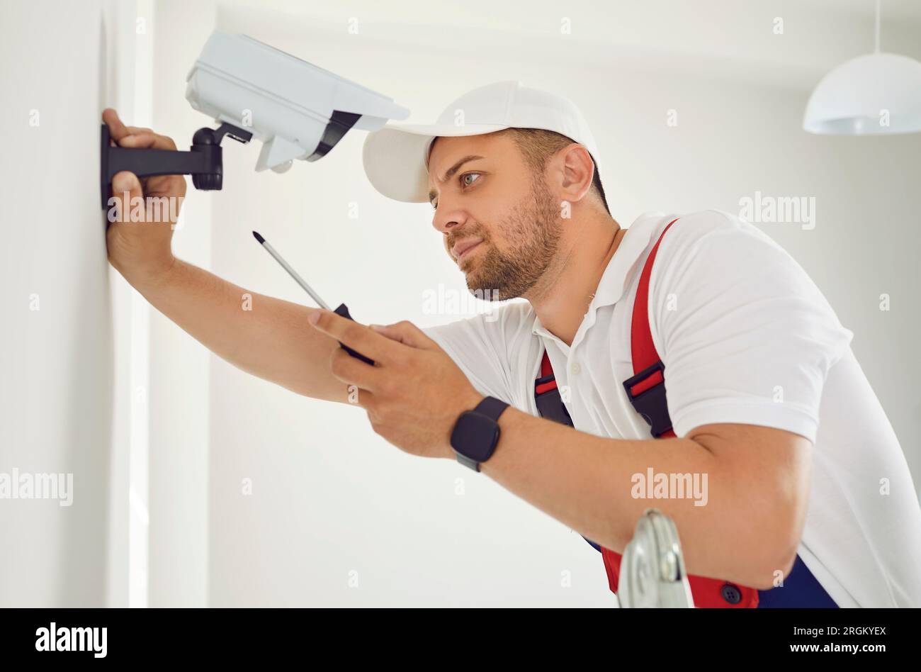 Male security camera installer installing or repairing surveillance ...