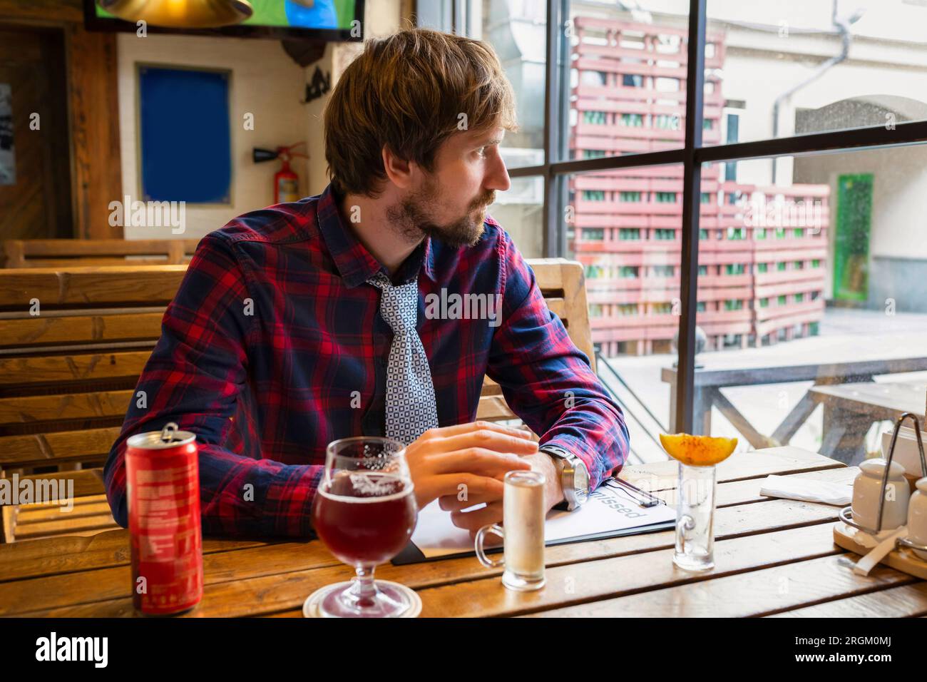 A frustrated young man drinking alcoholic sits alone in a bar. Sad ...
