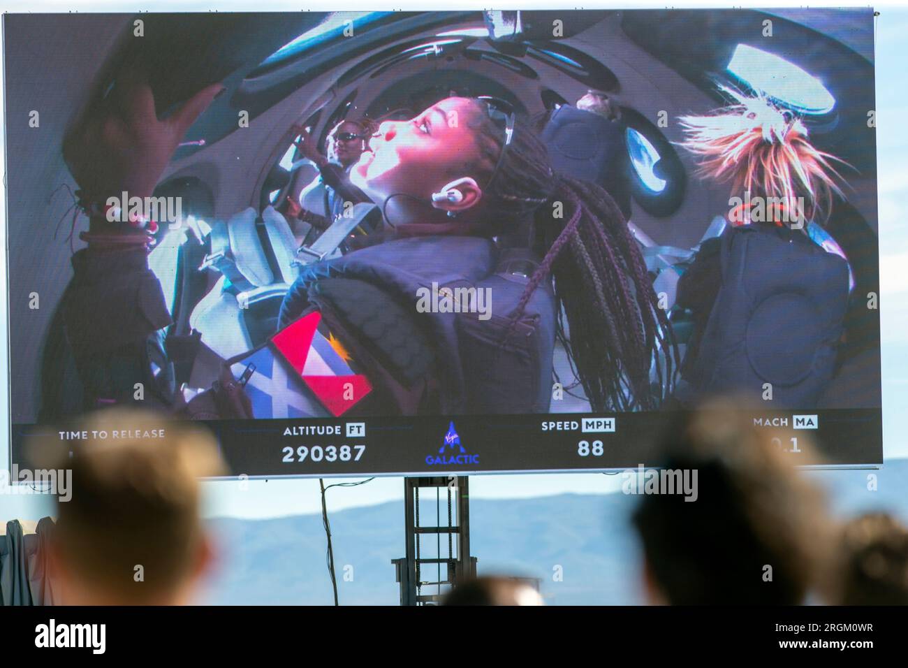 Guests watch a live broadcast from inside Virgin Galactic's rocket ...
