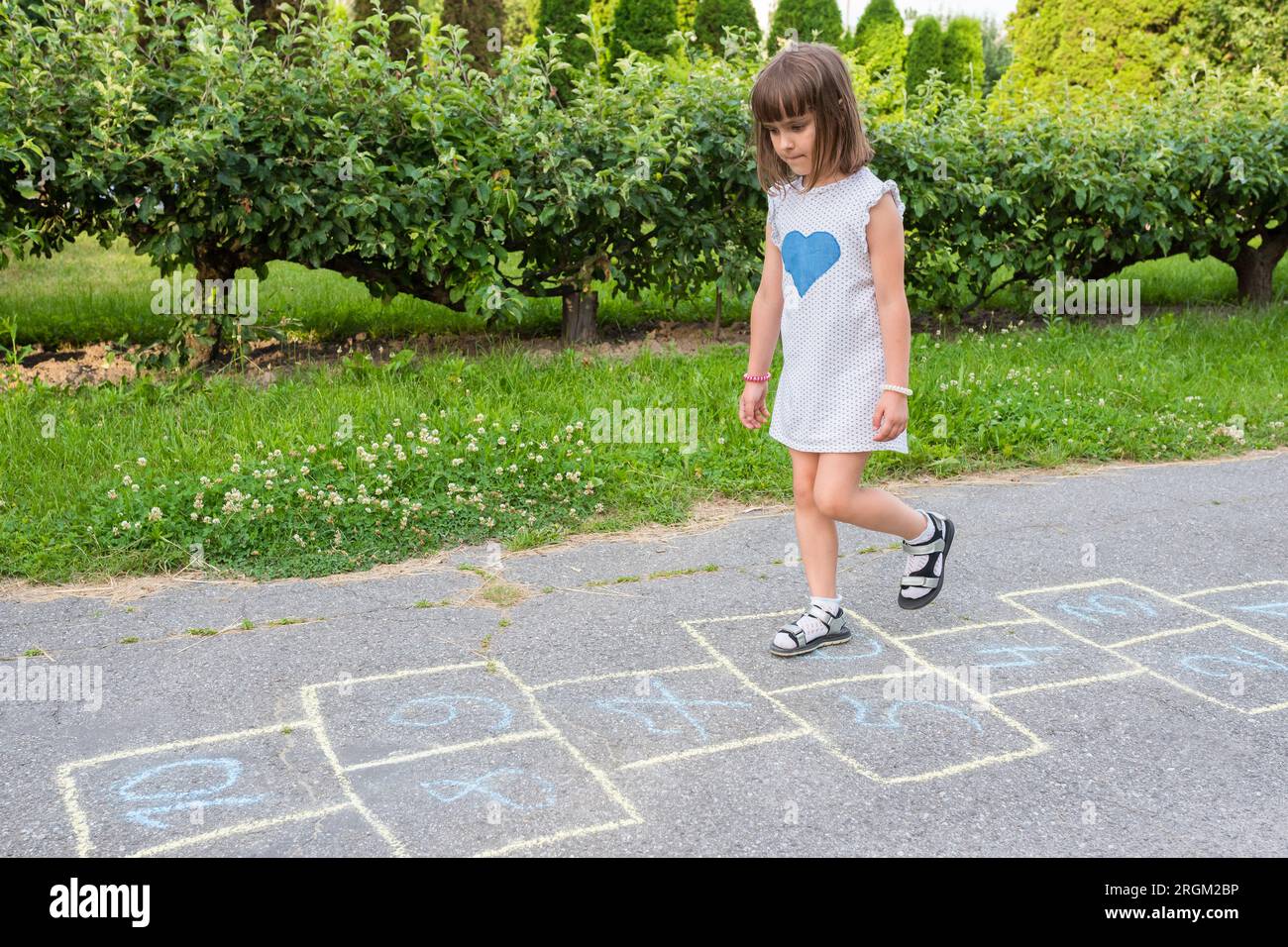 The child plays on the pavement in children's games Stock Photo - Alamy