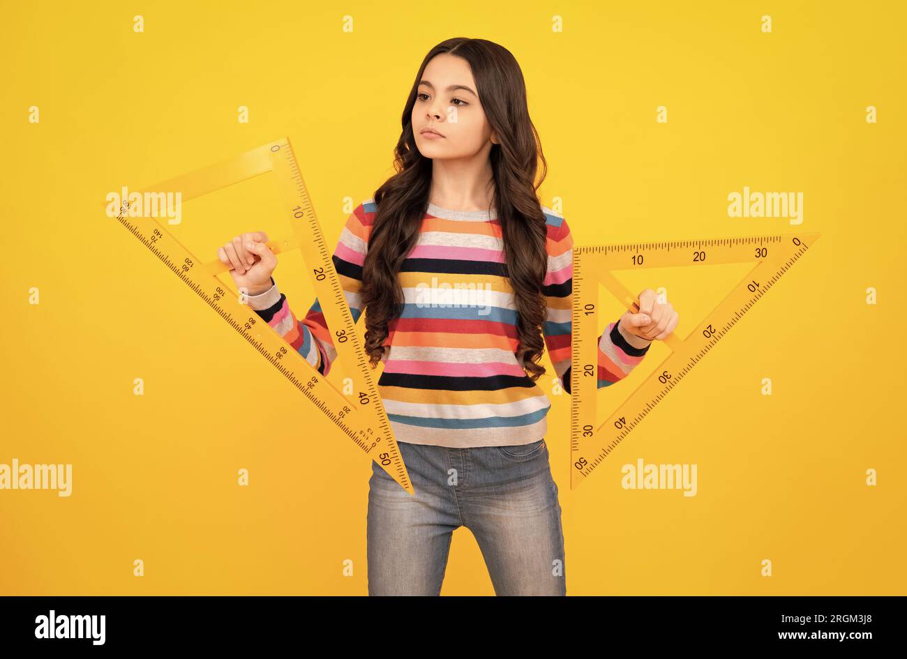 Back to school. School girl hold ruler measuring isolated on yellow ...