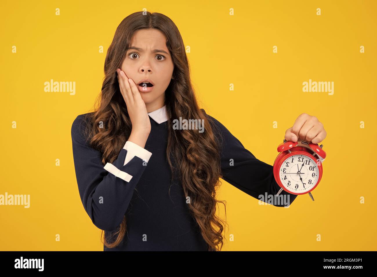 Teen student girl hold clock isolated on yellow background. Time to ...