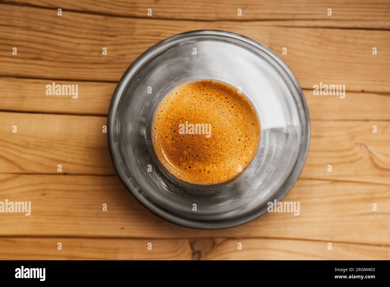 Top view of a glass cup of freshly brewed black espresso coffee with ...