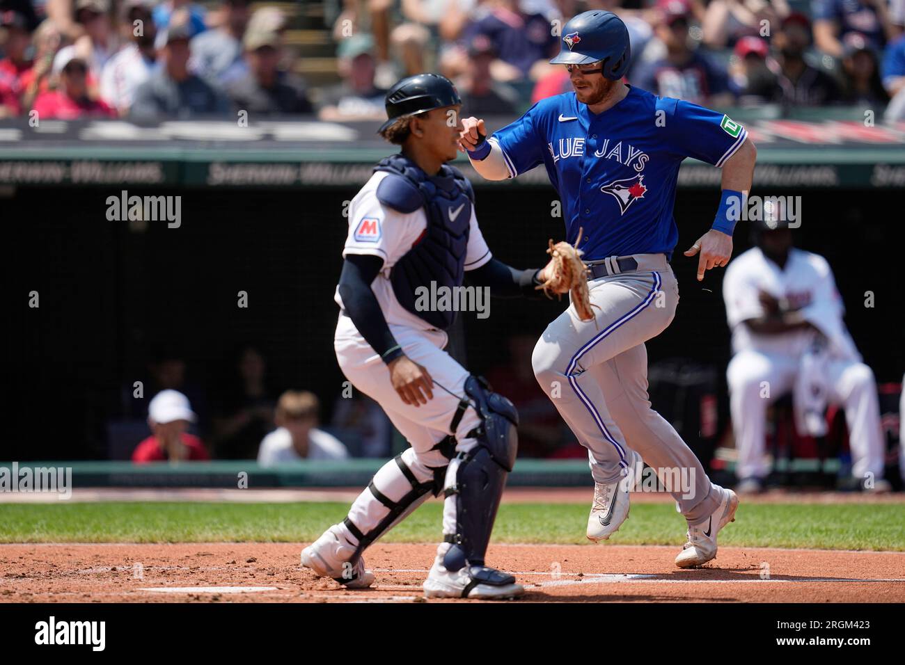 Toronto Blue Jays' Danny Jansen scores behind Cleveland Guardians catcher Bo Naylor, left, in ...