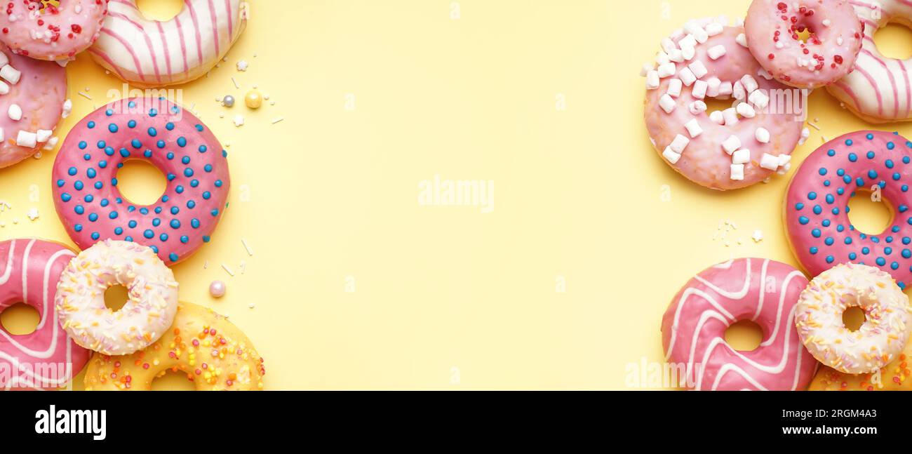 Different delicious donuts on light yellow background with space for ...