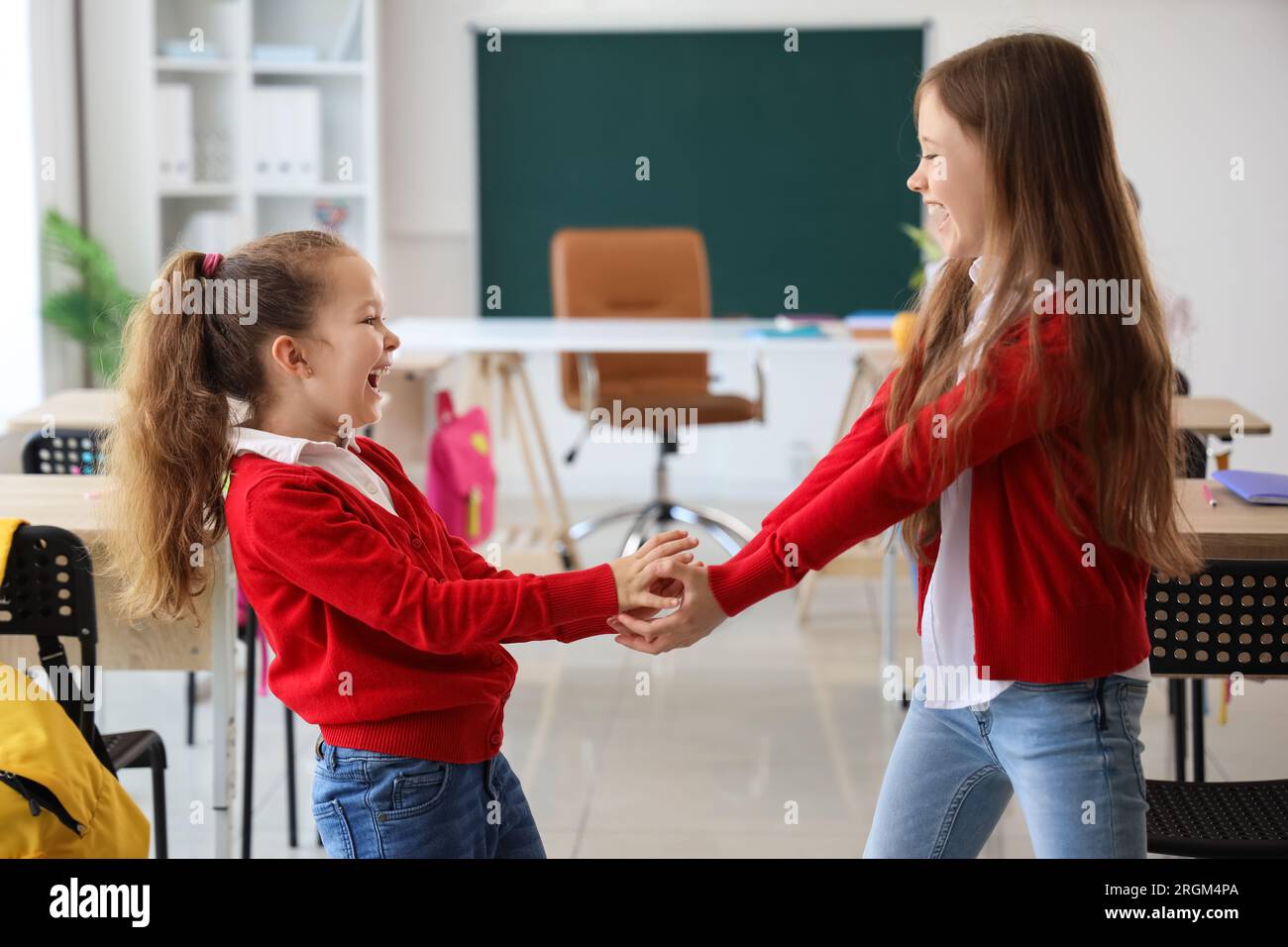 Happy little girls in classroom Stock Photo - Alamy