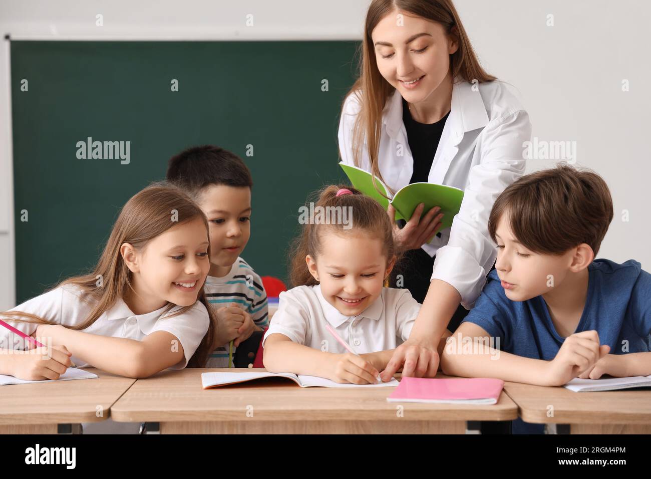 Little pupils having lesson with teacher in classroom Stock Photo - Alamy