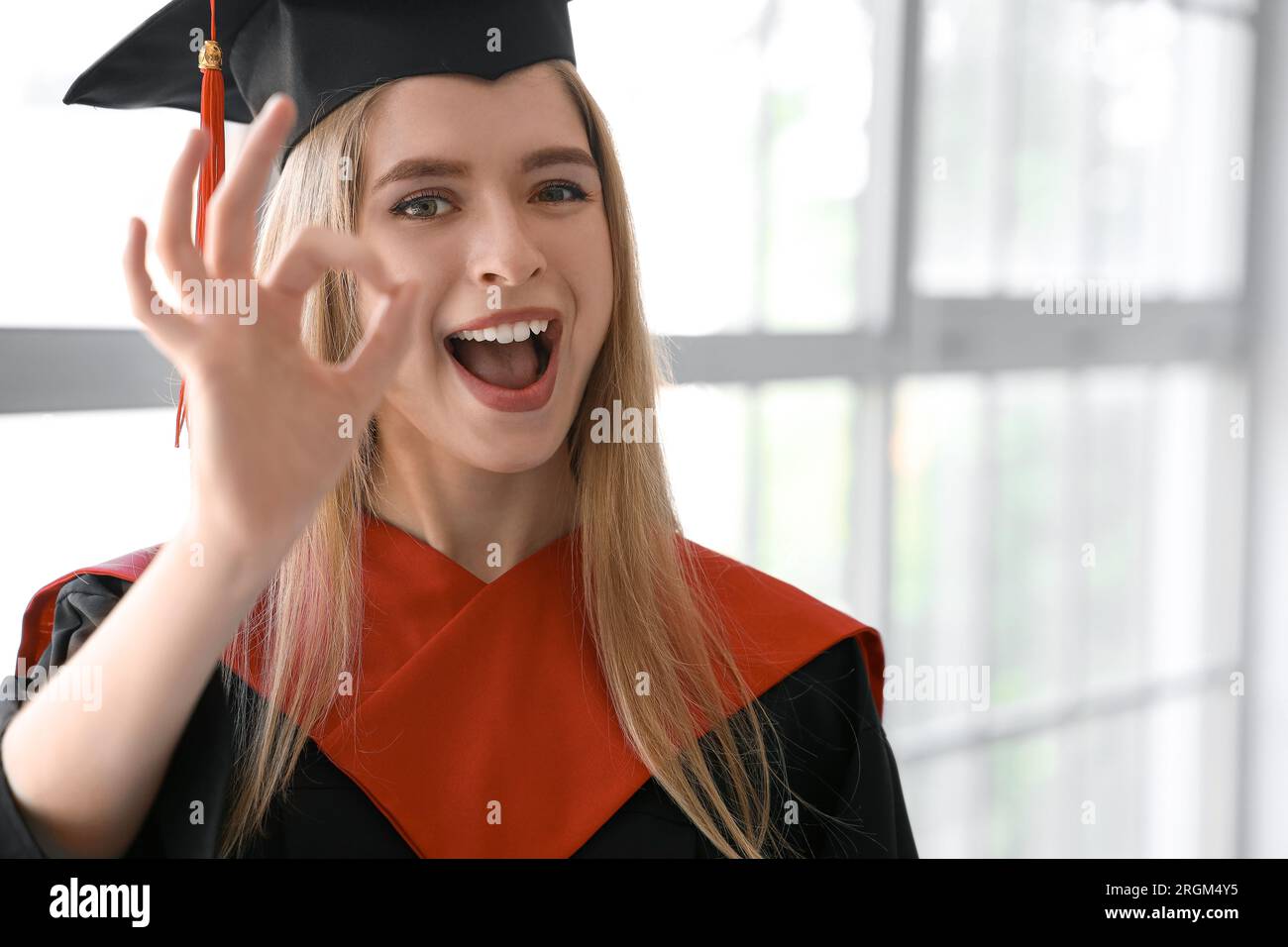 Female graduate student showing OK near window in room, closeup Stock ...