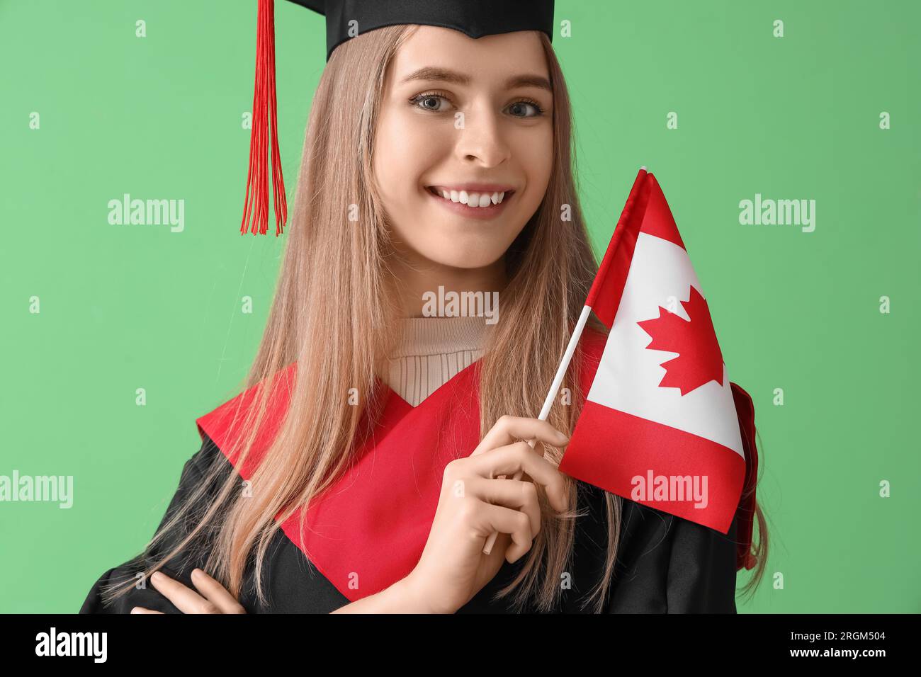 Female graduate student with Canadian flag on green background, closeup ...