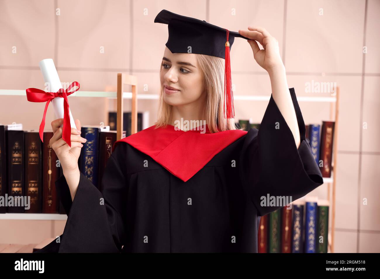 Female graduate student with diploma in library Stock Photo - Alamy