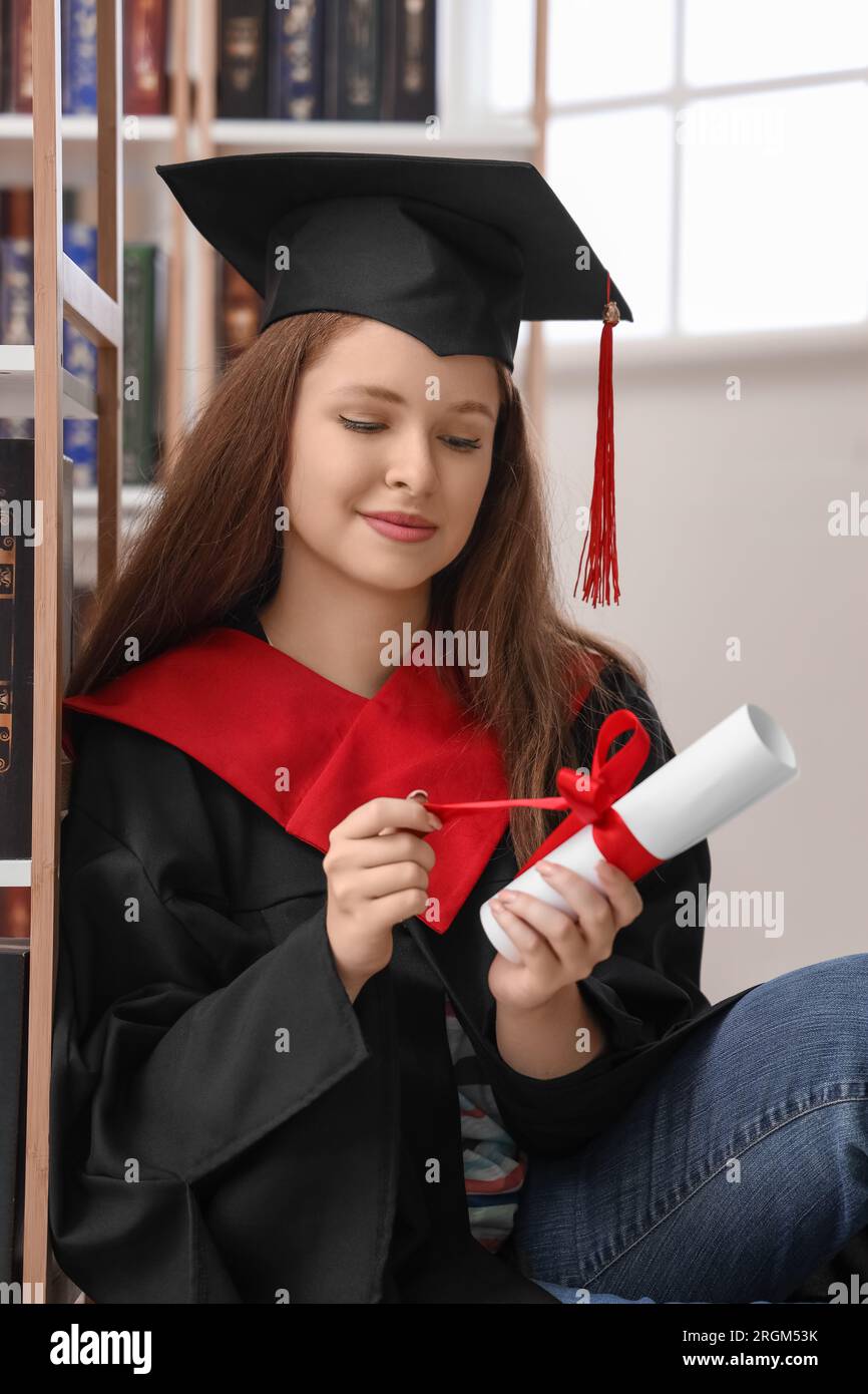 Female graduate student with diploma in library Stock Photo - Alamy