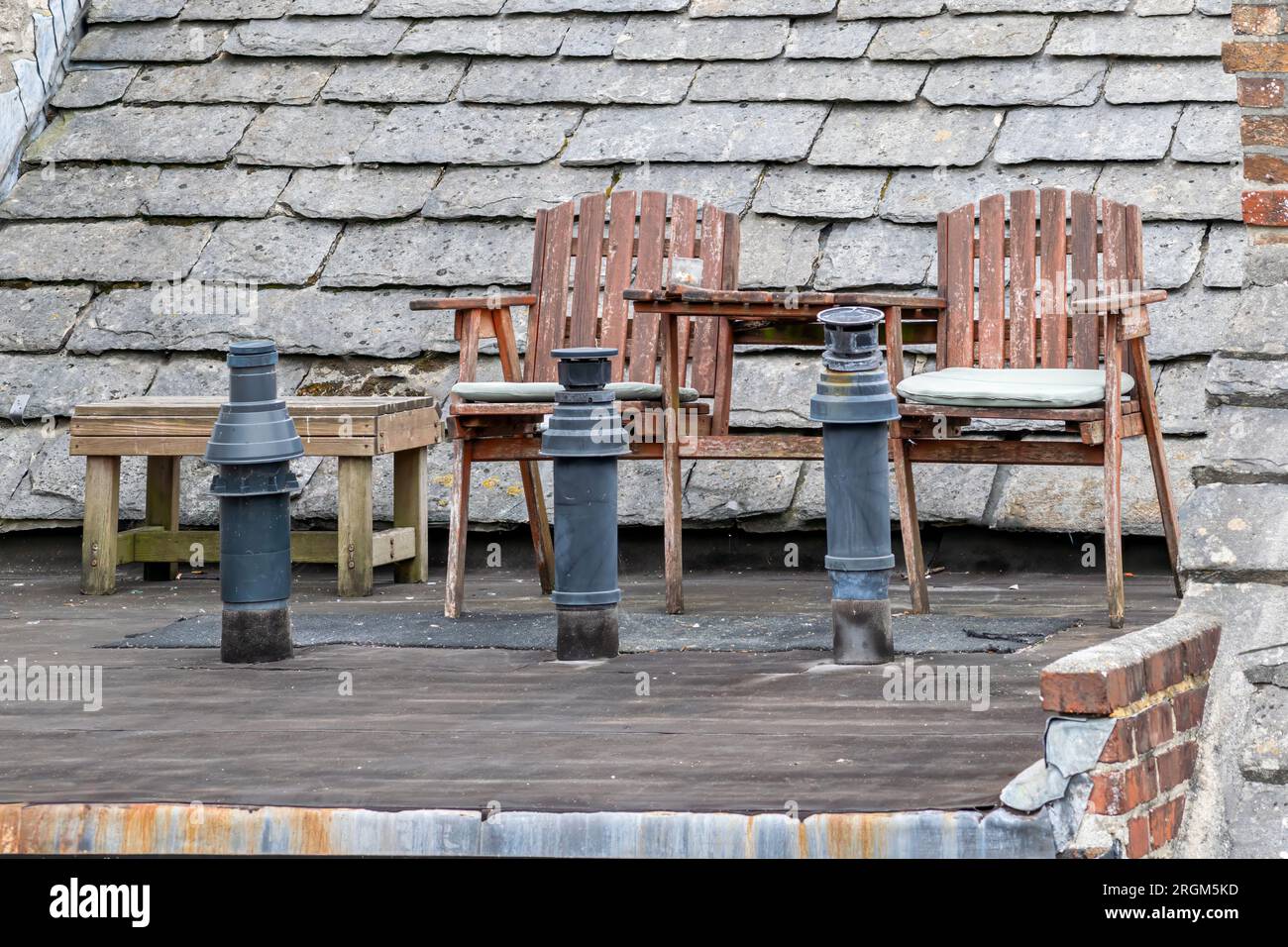 Two wooden chairs and a table on an old slate rooftop Stock Photo - Alamy