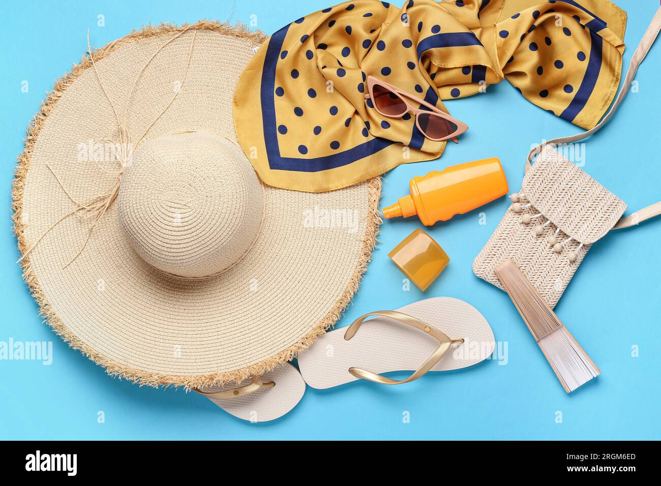 Composition with stylish beach accessories and bottle of sunscreen ...