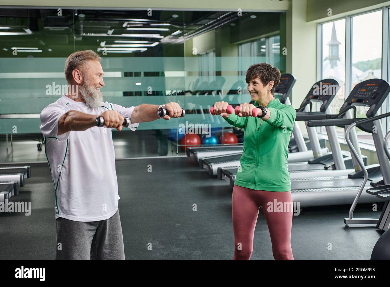 elderly couple, happy man and woman exercising with dumbbells, active seniors, husband and wife ...