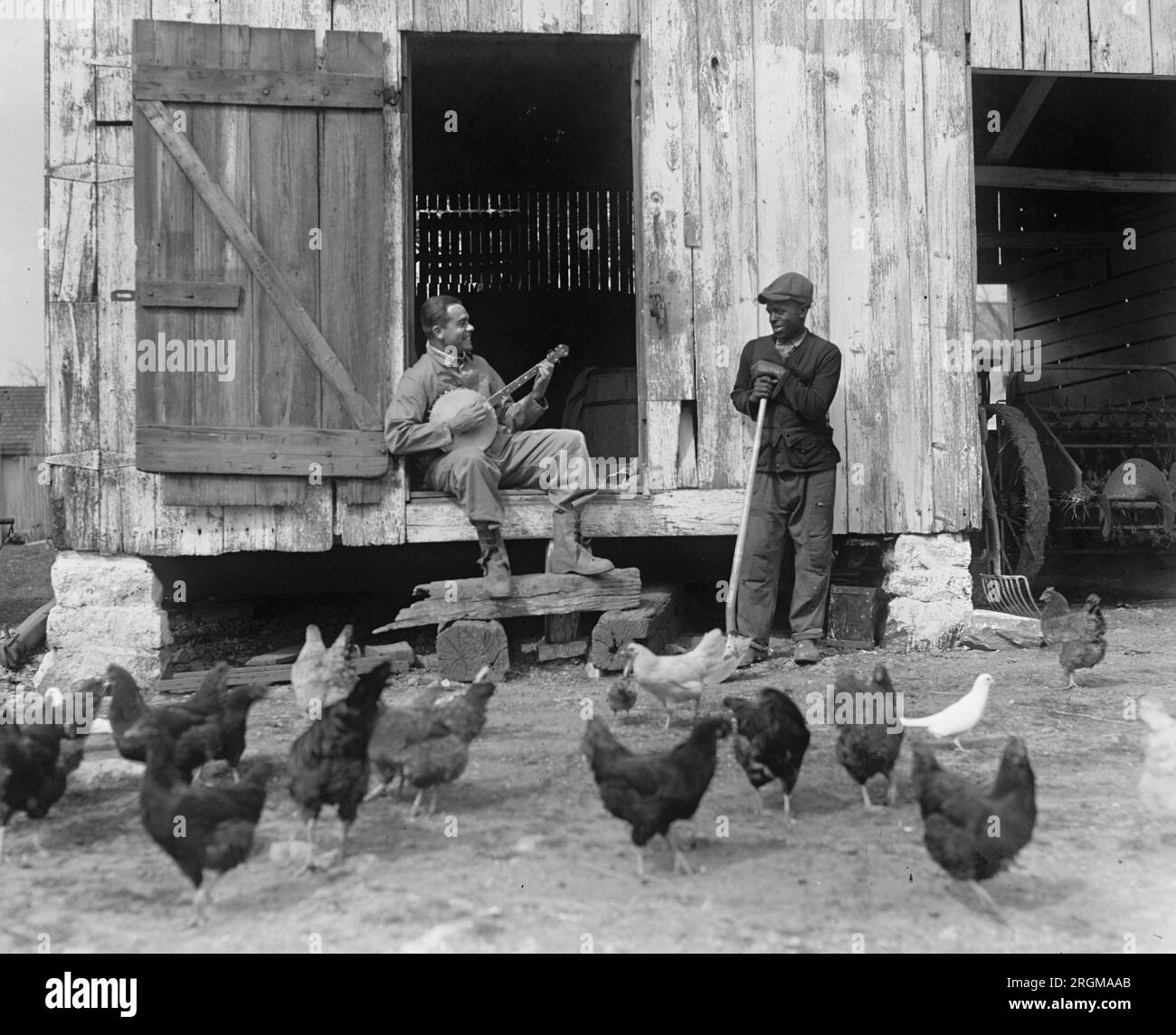 An African American man in a barnyard playing a banjo ca. 1927 Stock ...