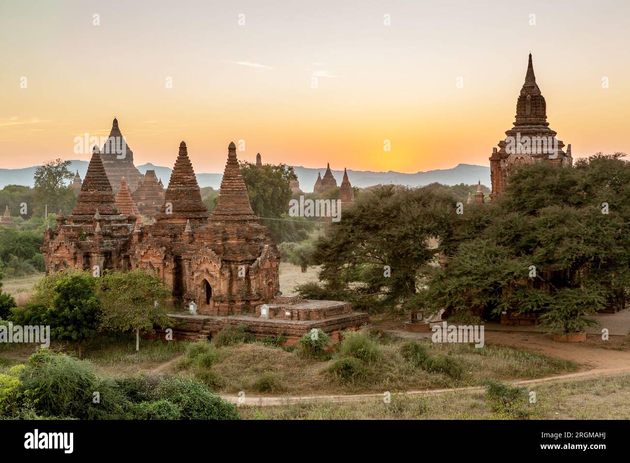 Old Burmese brick temples with green trees at sunset Stock Photo - Alamy