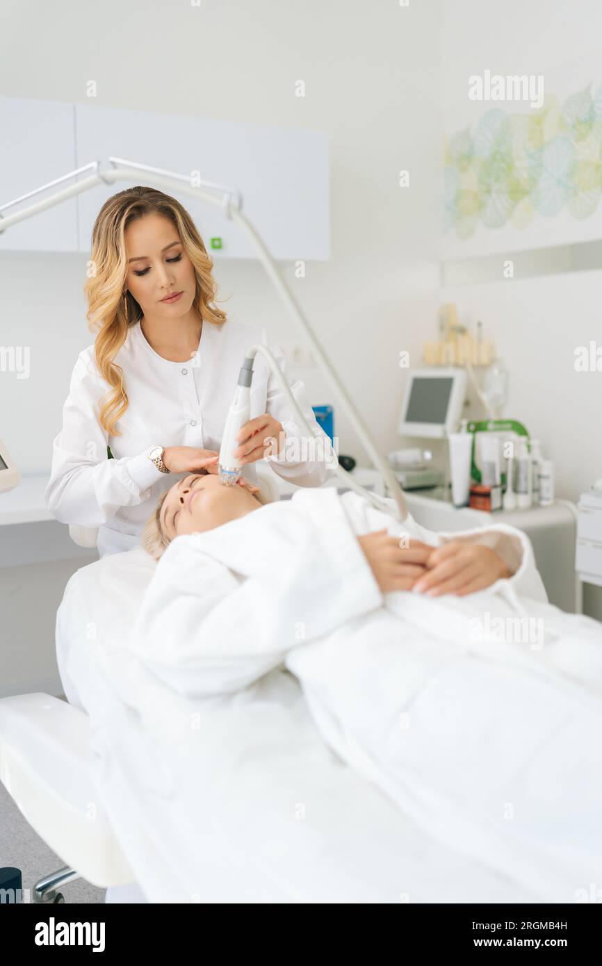 Vertical shot of laser rejuvenation technology for female patient using ...