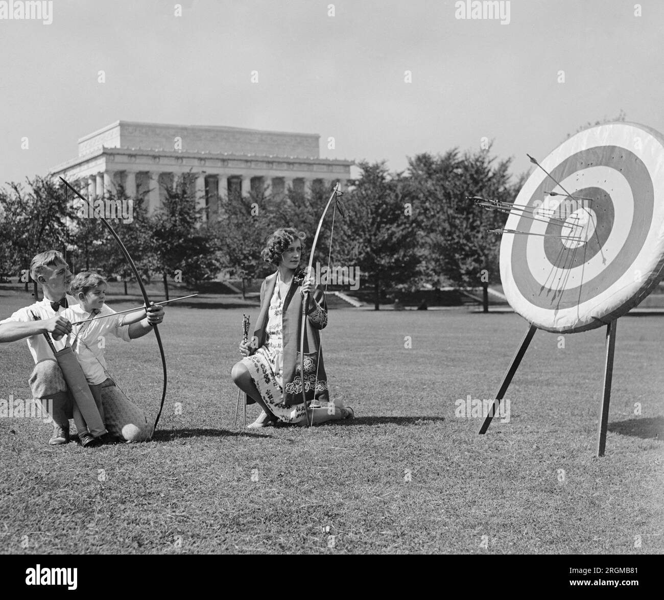 Vintage Archery: A toddler using a bow and arrow, shooting at a target ...