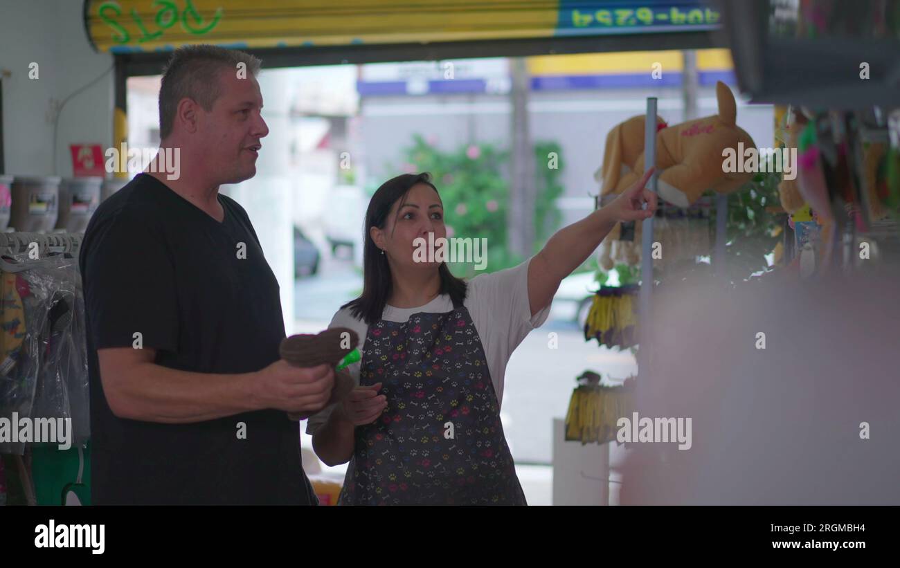 Female Owner Pet Shop helping customer to choose Dog toys inside Store ...