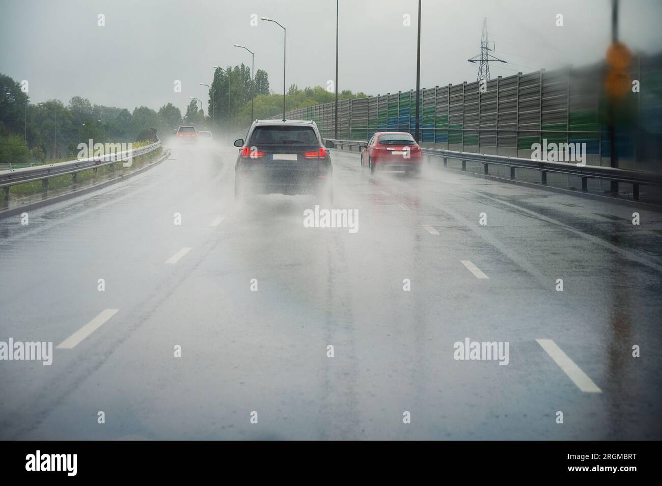 Cars driving on the road, heavy rain, low visibility, slippery street ...