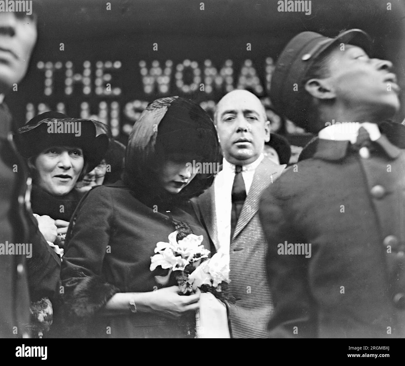 Actress Mildred Harris Chaplin walking through a crowd outside a movie ...