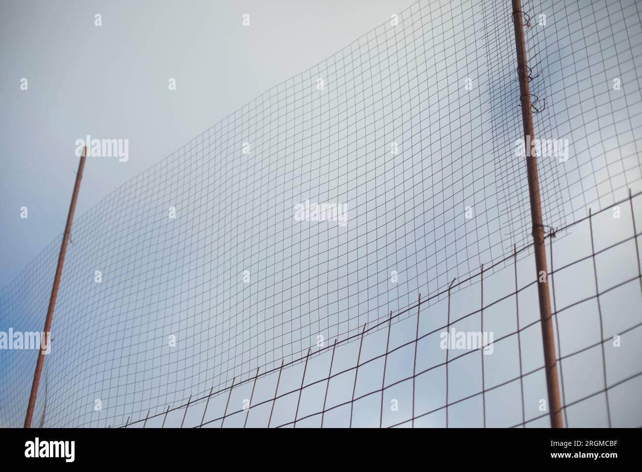 High fence. Steel mesh in stadium. Fence from ball. Stadium details ...