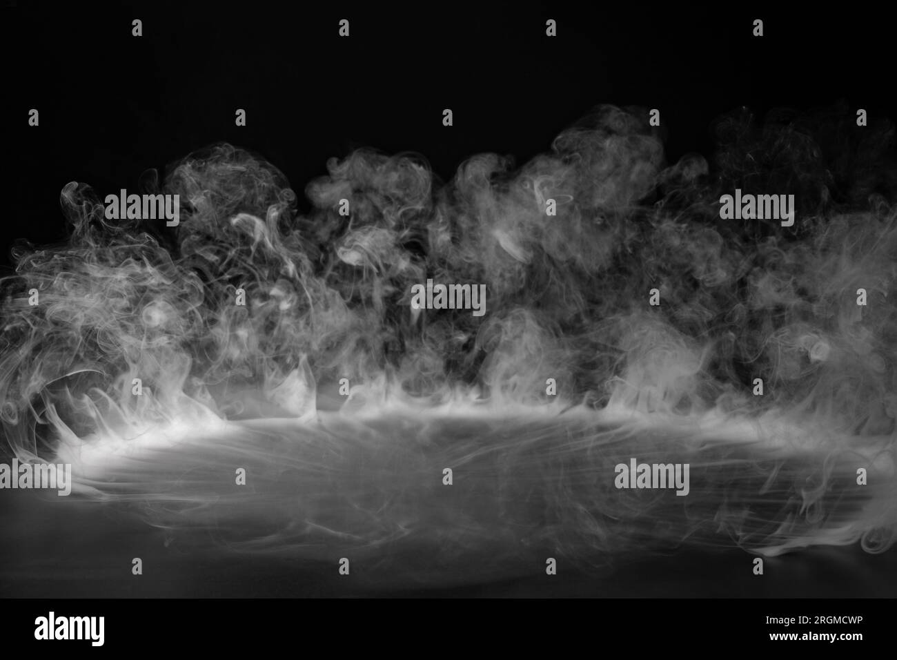 Fog or steam on black background flowing or rolling from center to ...