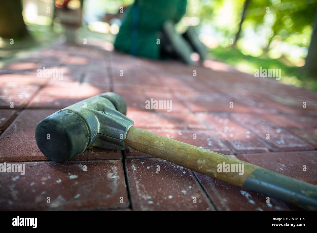 A hammer with rubber tips lies on the paving stones and in the ...