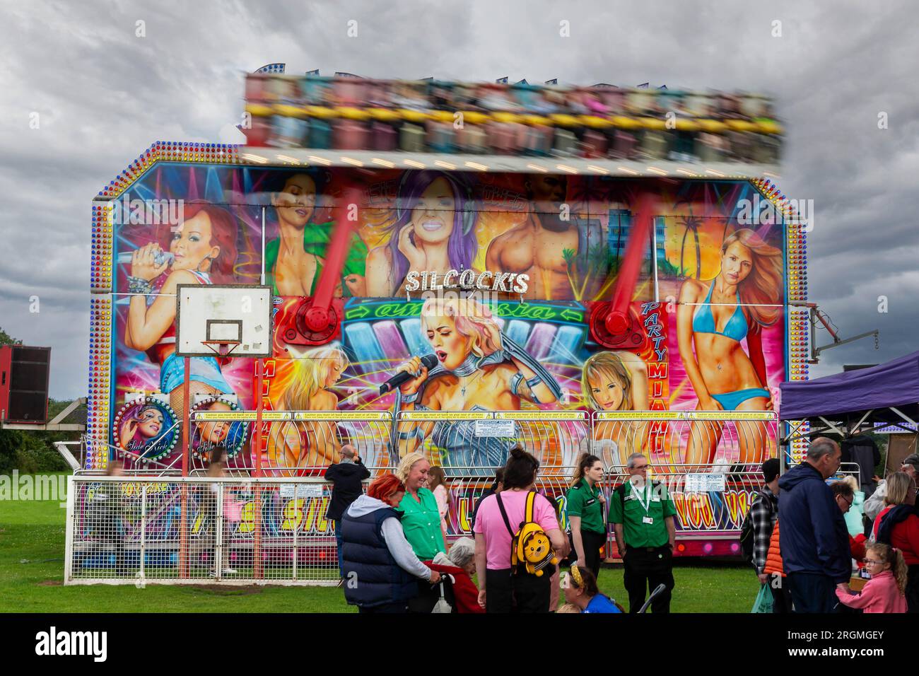 Children having fun on a moving, rotating, colourful funfair ride ...