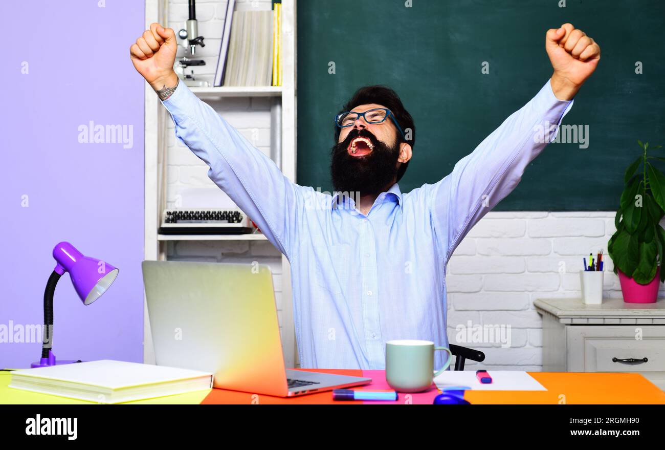 Excited male student with raised hands at classroom. Success. Creative ...