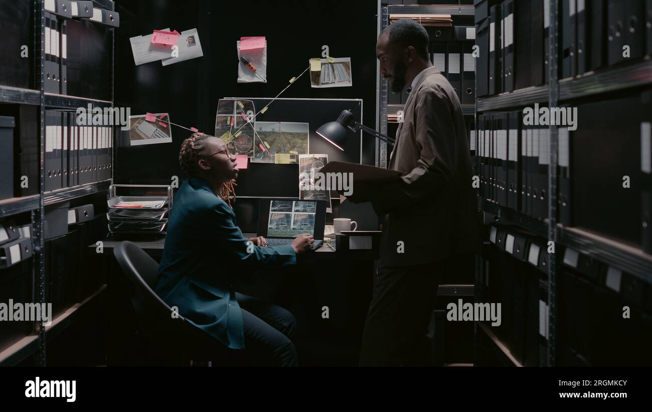 Law agents team analyzing private records in evidence room, conducting ...