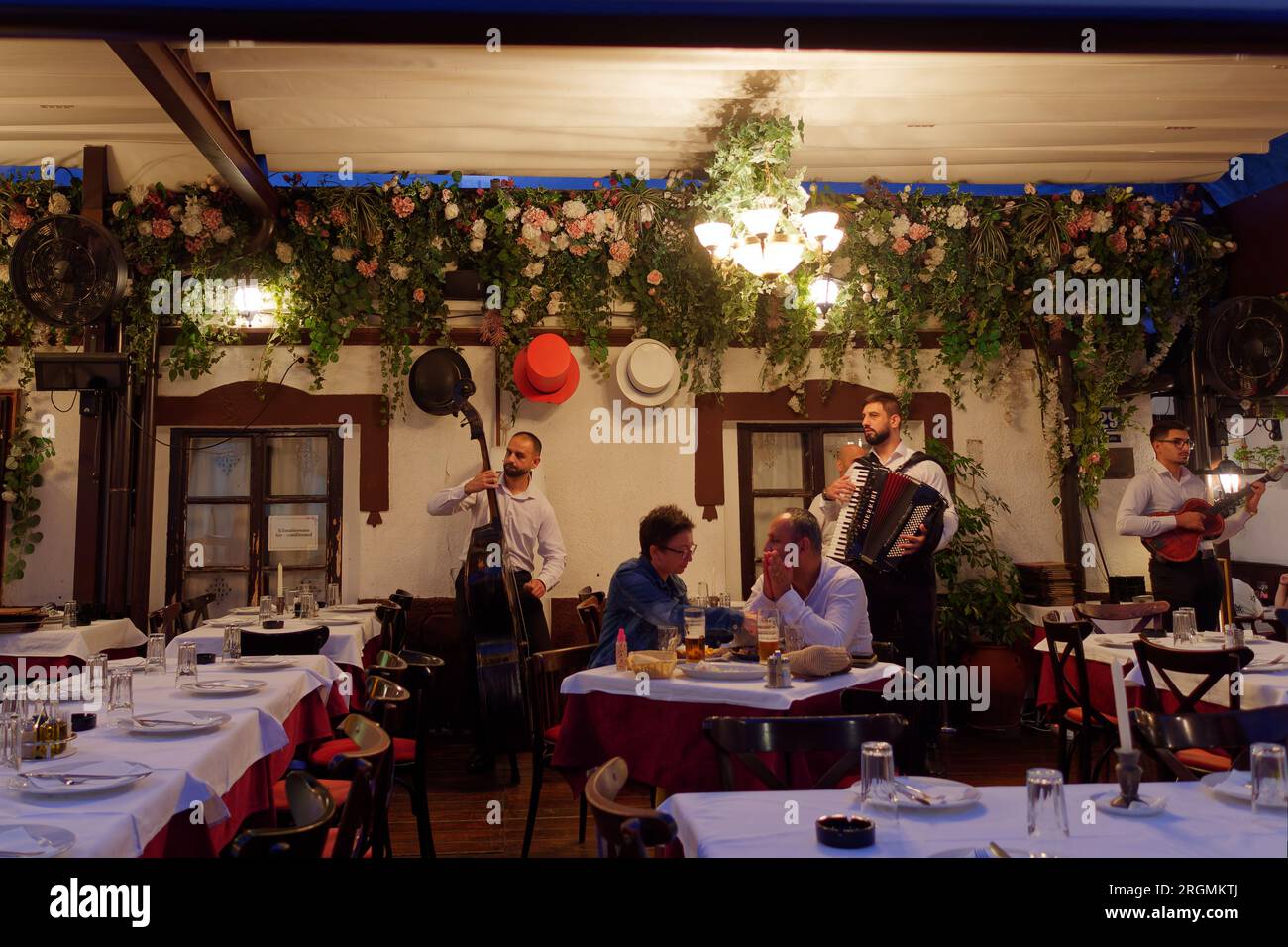 Musicians play at the famous Three Hats restaurant in front of guests ...
