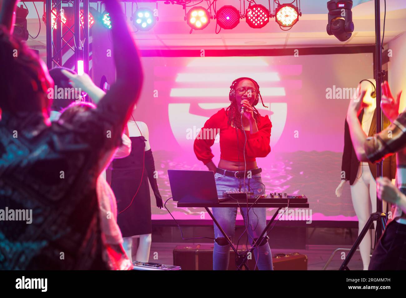 Musician singing and playing electronic music on stage in nightclub ...