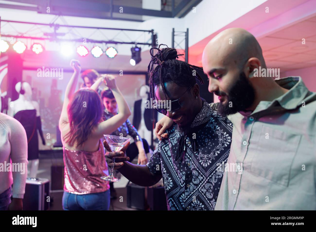 Smiling diverse men friends hugging, drinking alcohol and partying in ...