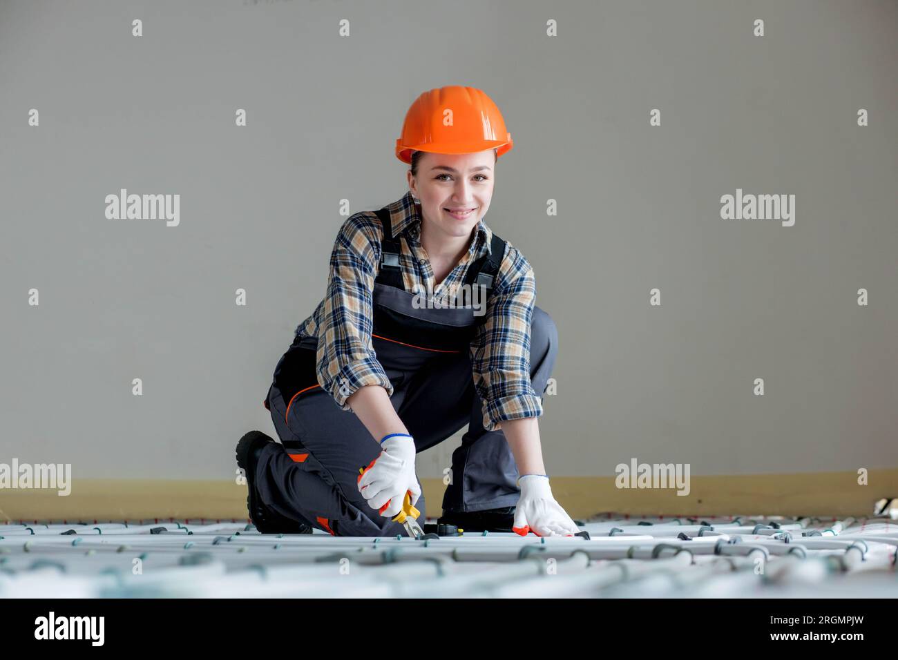 Portrait of woman worker which is installing underfloor heating system ...