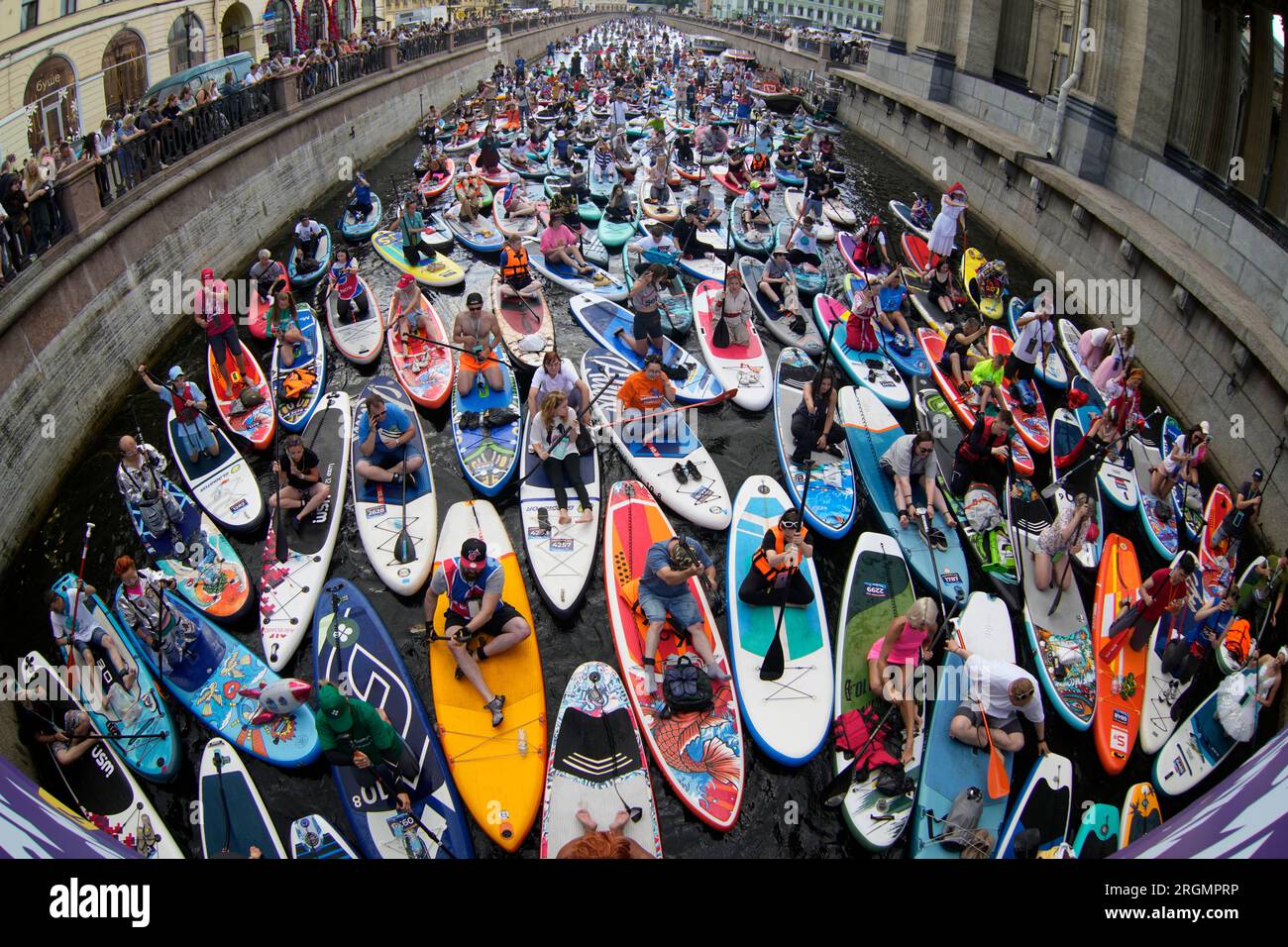 People steer their stand-up paddle (SUP) boards along the Griboedov ...