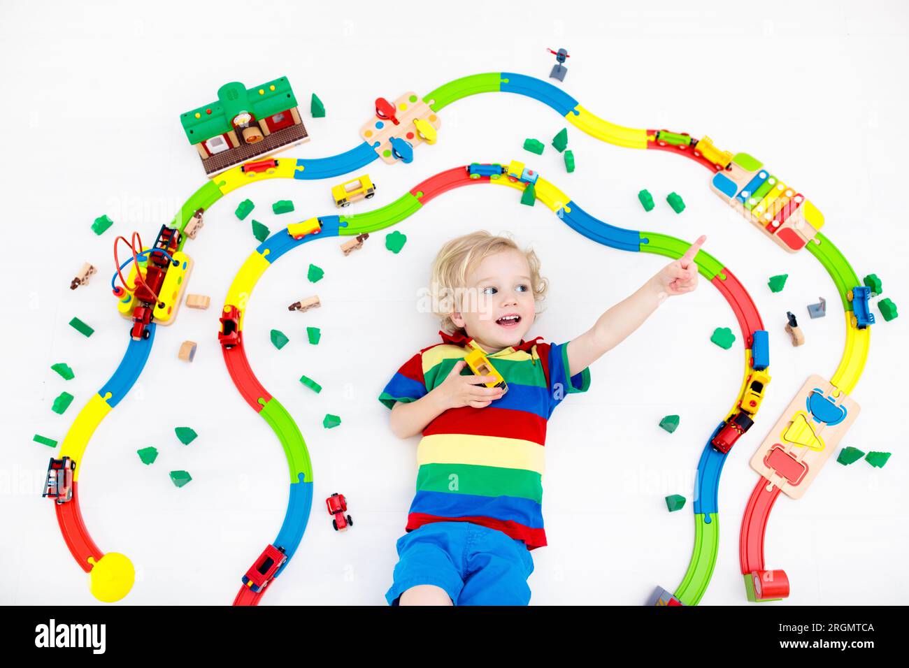 Kids play with toy train railway. Child playing with colorful rainbow ...