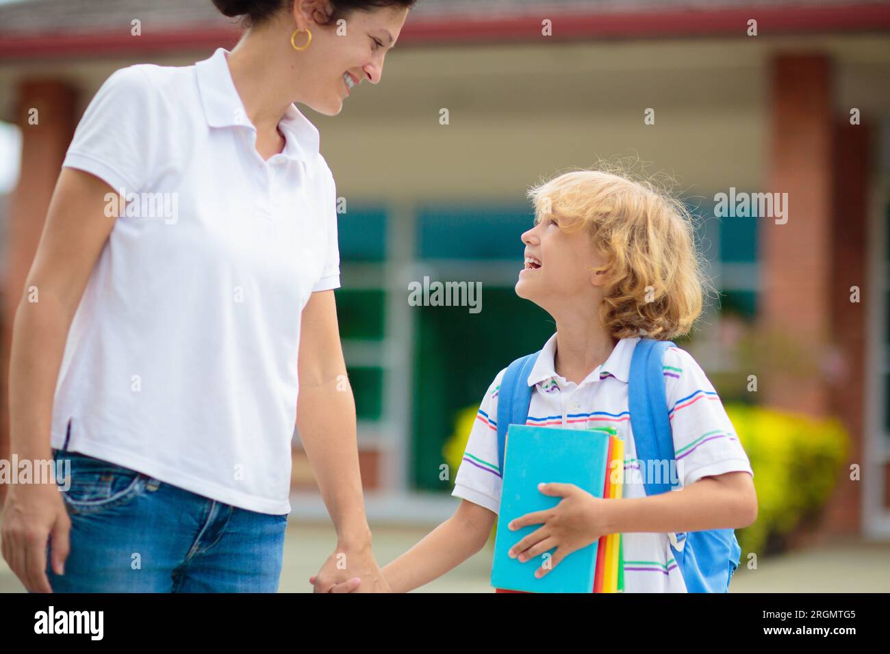 Mother bringing child to school. Parents pick up little boy after class ...