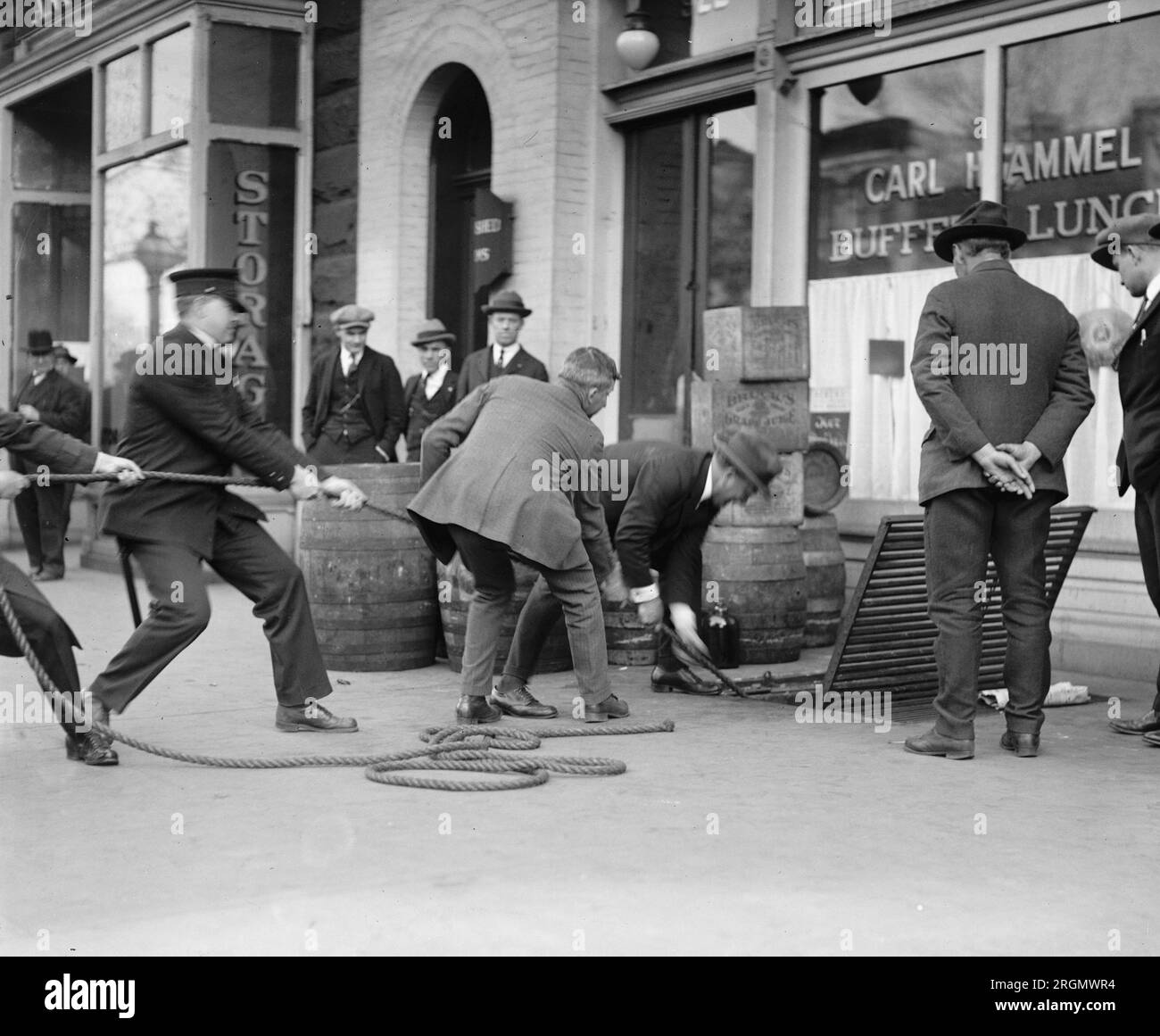 Officers and agents conducting a liquor raid, confiscating liquor ...