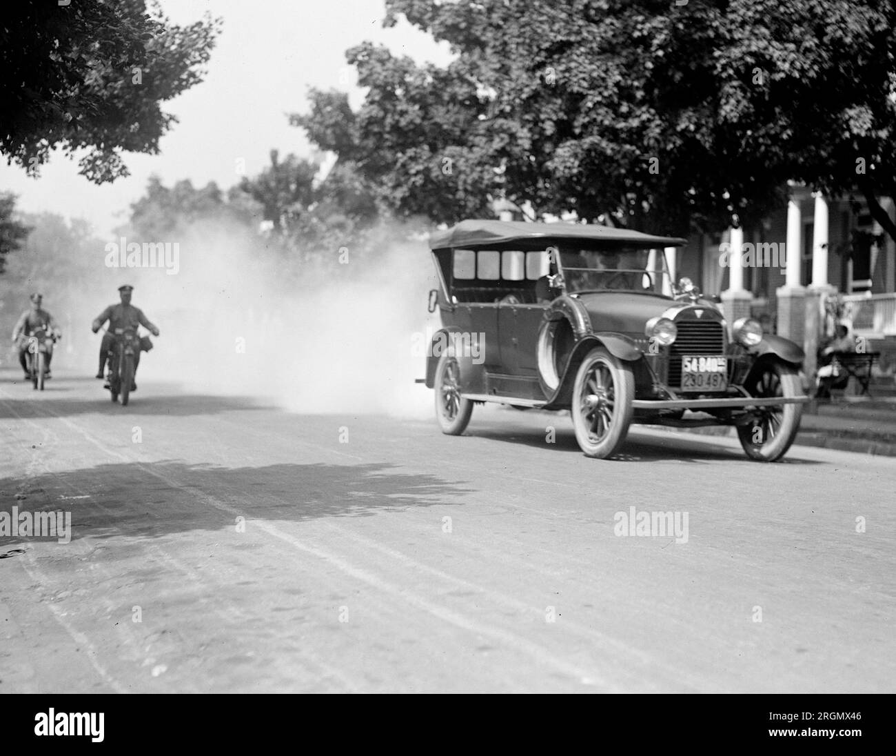 Police on motorcycle trailing car with smoke ca. 1923 Stock Photo - Alamy