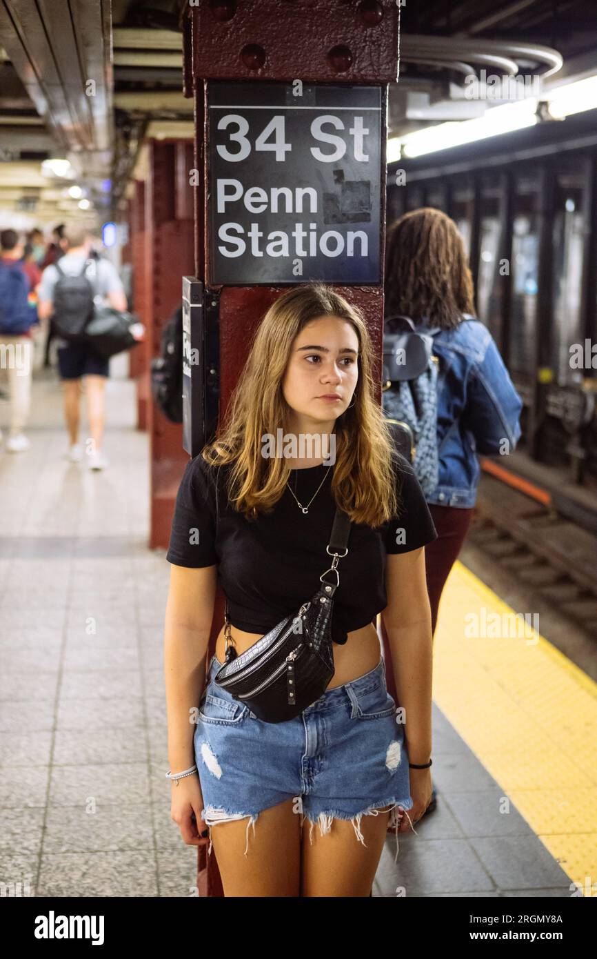 Girl posing resting on a column with the 34 street Penn Station subway ...