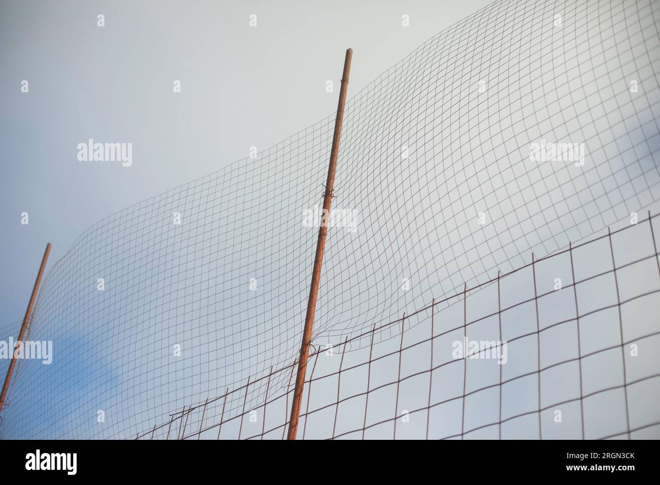 High fence. Steel mesh in stadium. Fence from ball. Stadium details ...